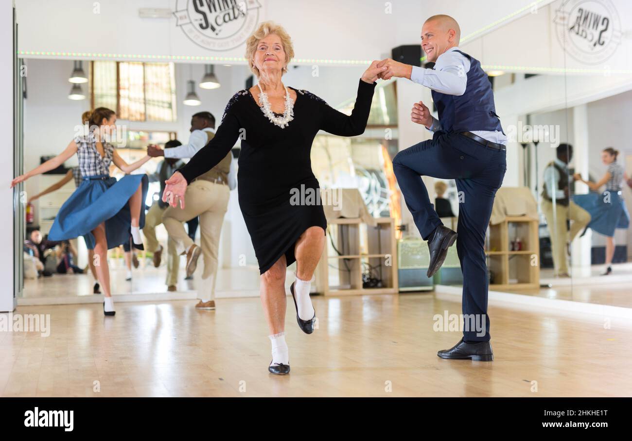 Man and elderly woman performing jazz dance in dancing room Stock Photo ...