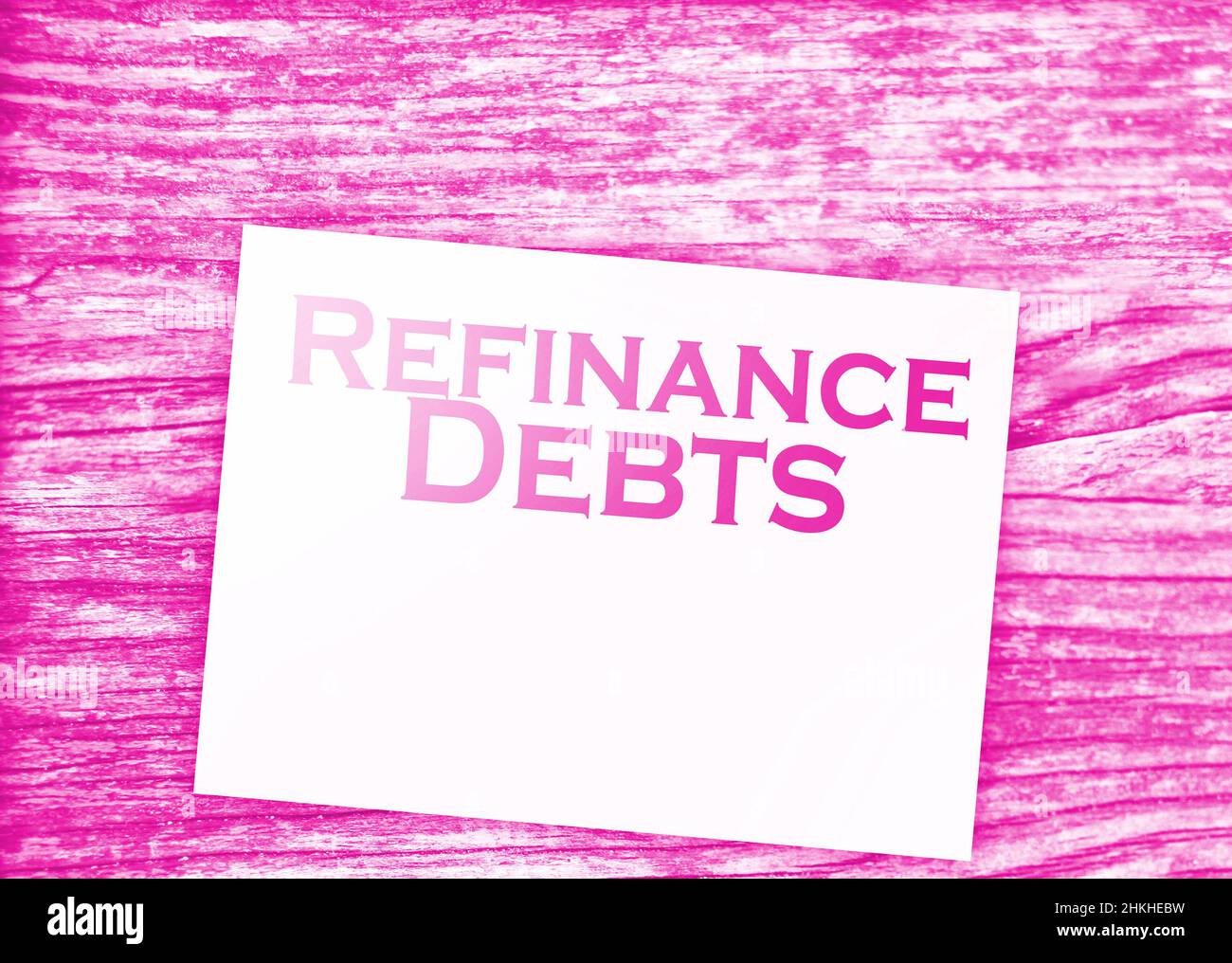 REFINANCE Debts Words on page and paper dollar signs around on wooden ...
