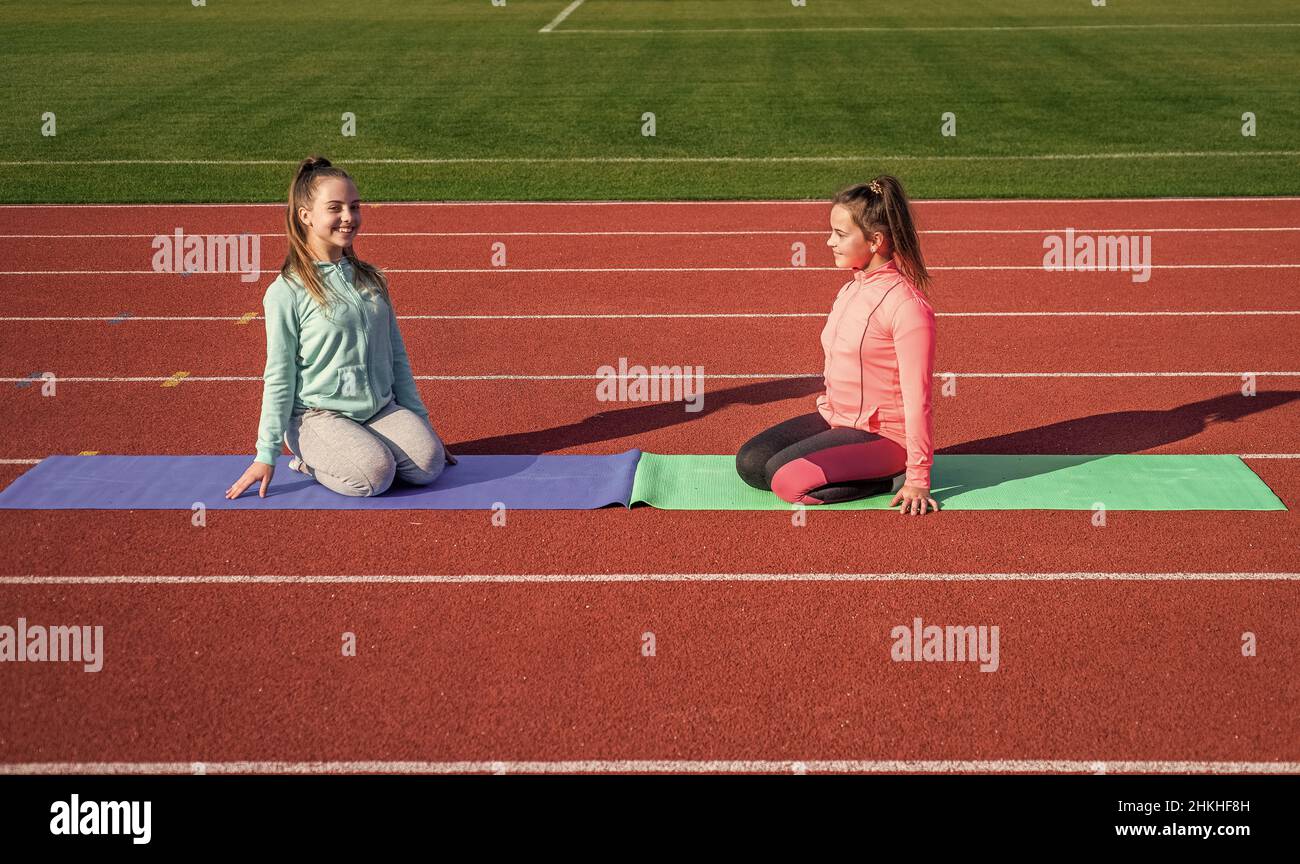 healthy children girls training fitness on stadium running track, yoga ...