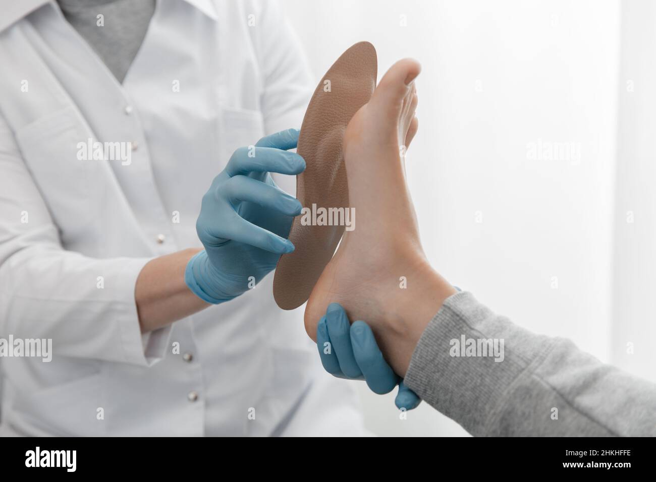 Doctor hands hold an orthopedic insole. Orthopedist tests the medical ...