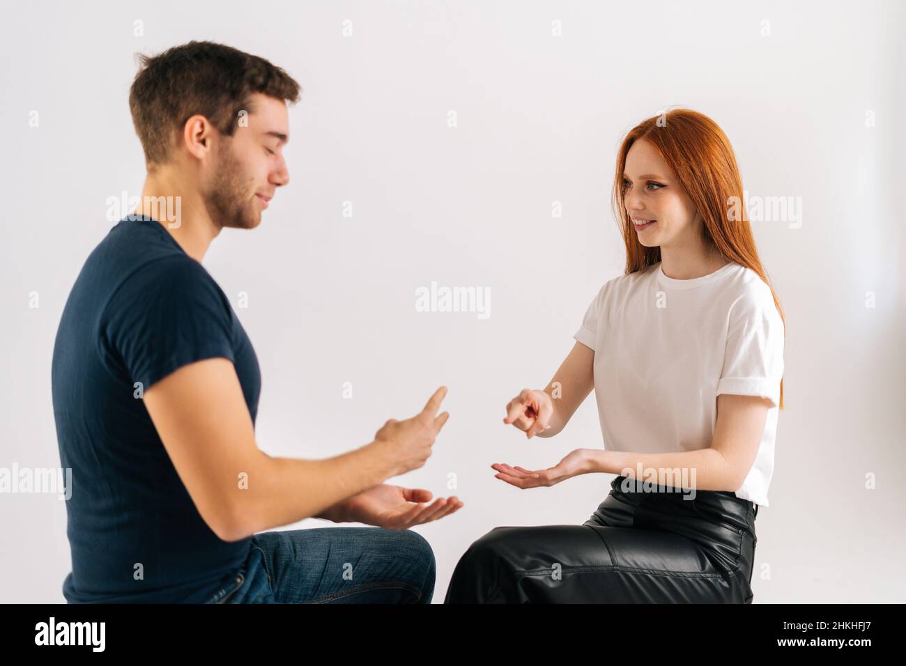 Studio shot of cheerful beautiful young man and woman playing rock ...