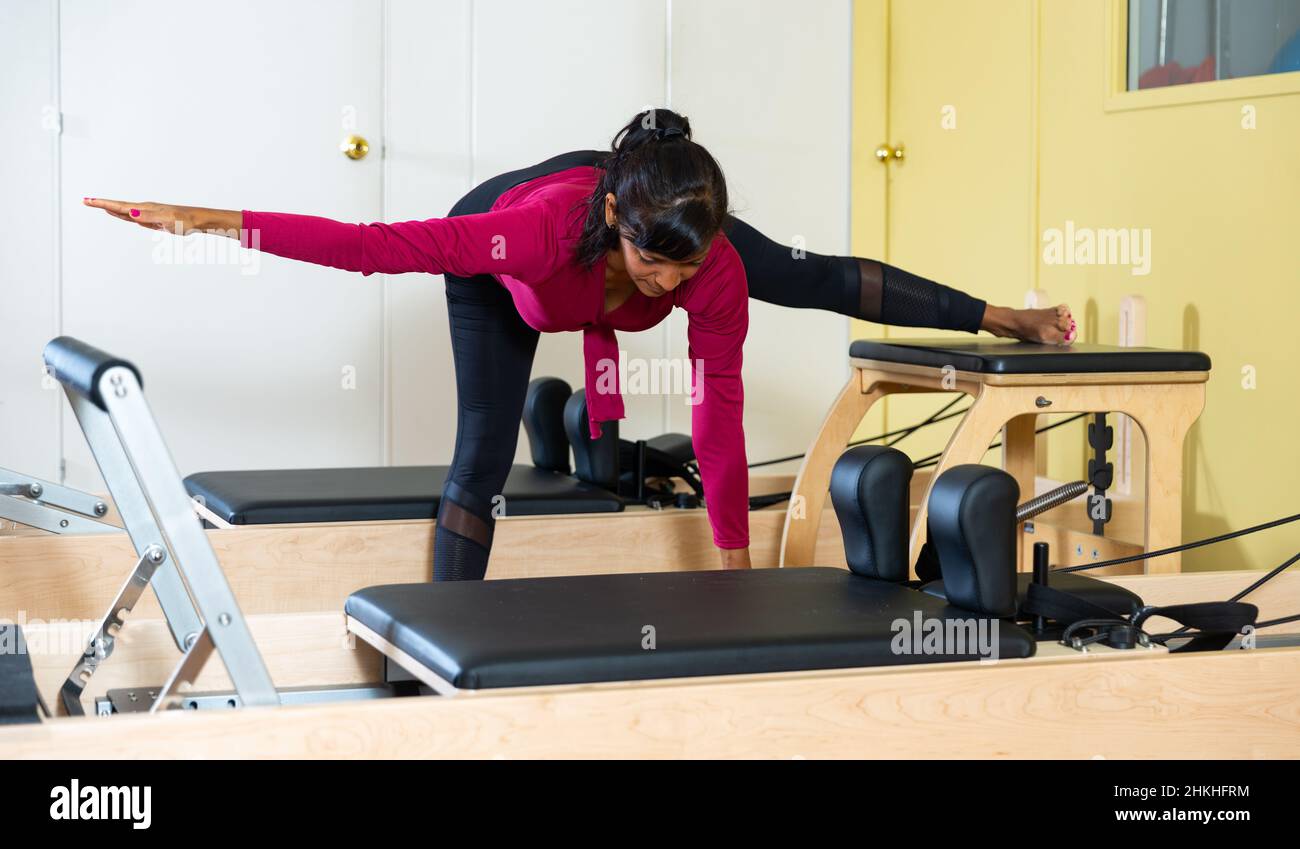 Pilates trainer demonstrates various exercise machine exercises in ...