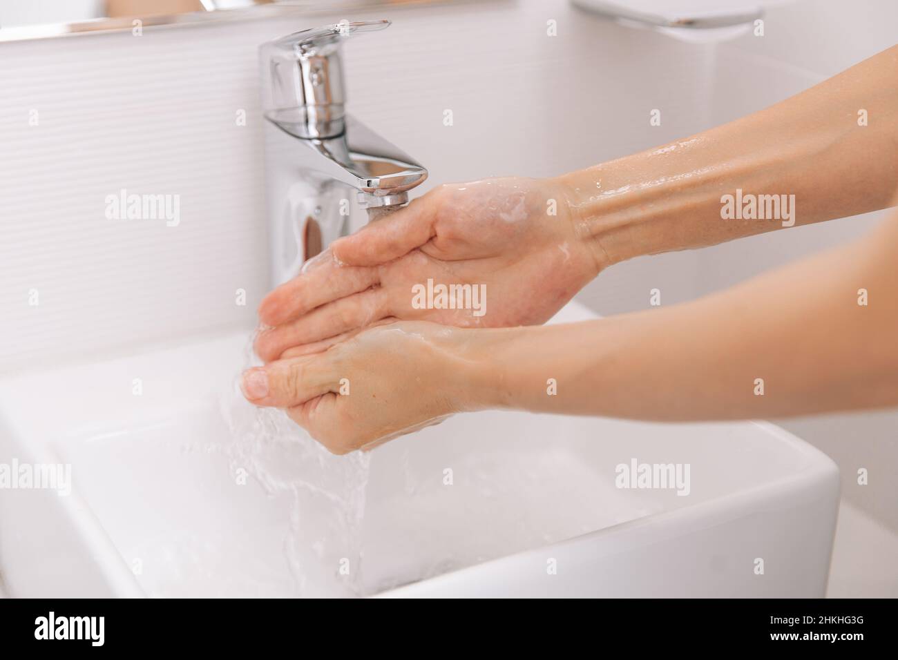 Washing hands under the flowing water tap. Hygiene concept hand detail ...