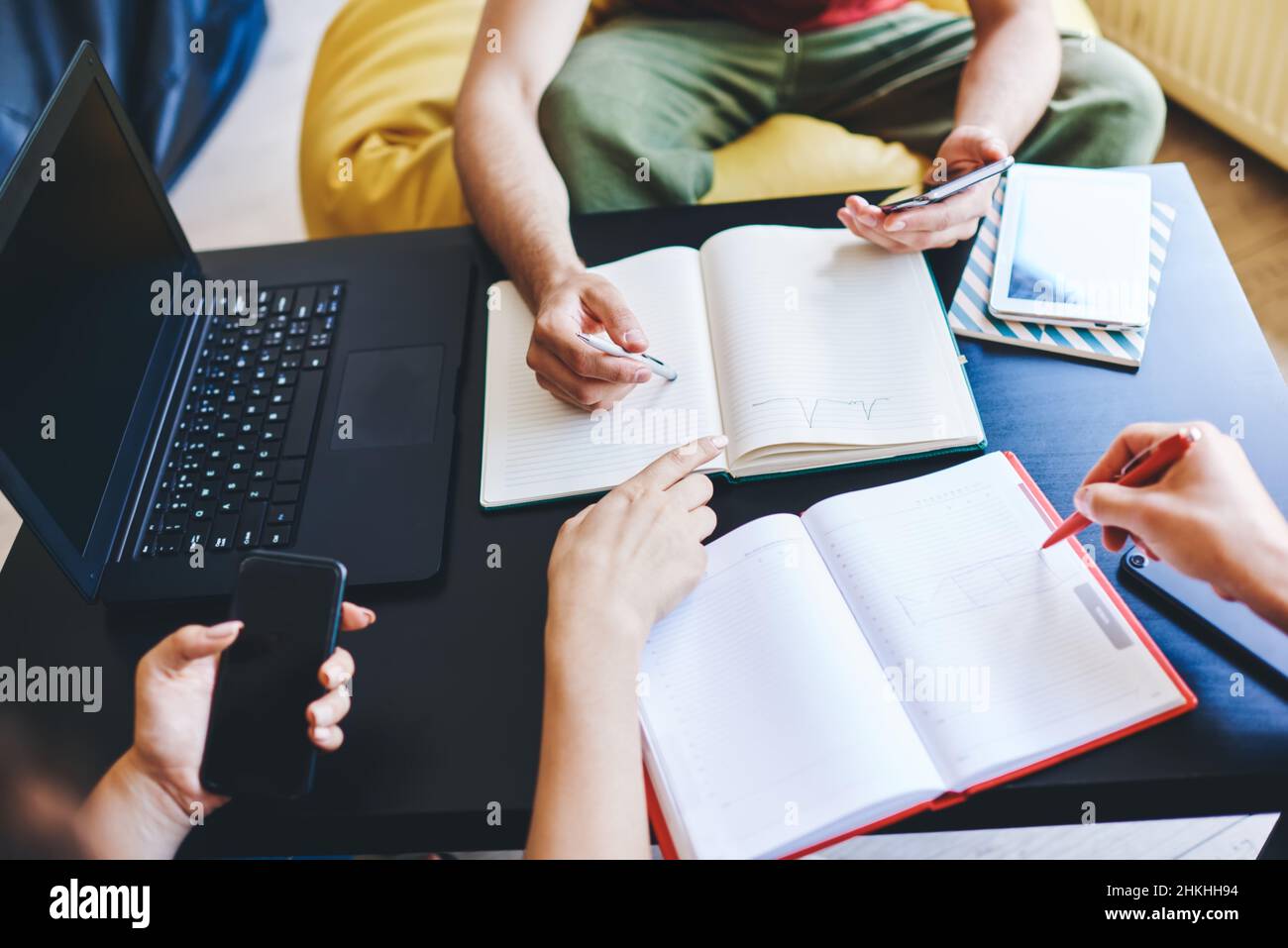 Crop students doing homework together in workplace Stock Photo - Alamy