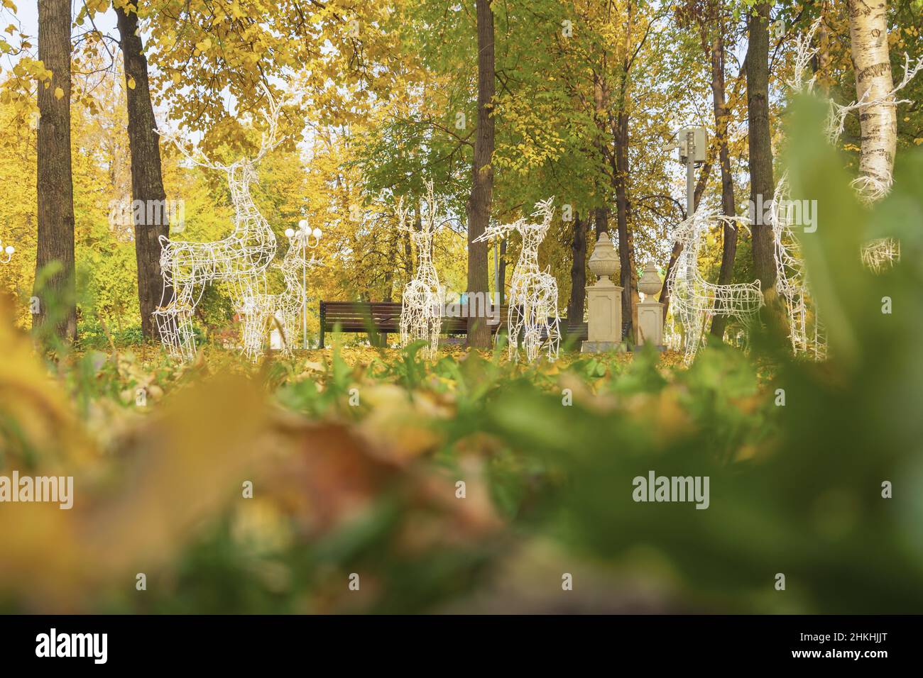 Installation of a herd of deer in the autumn city park among the yellow ...