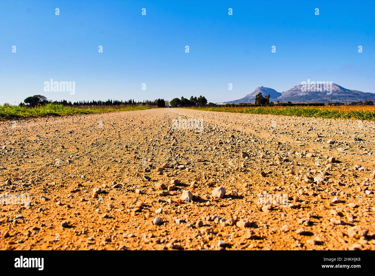 Dirt road and stones in rural area and field Stock Photo - Alamy