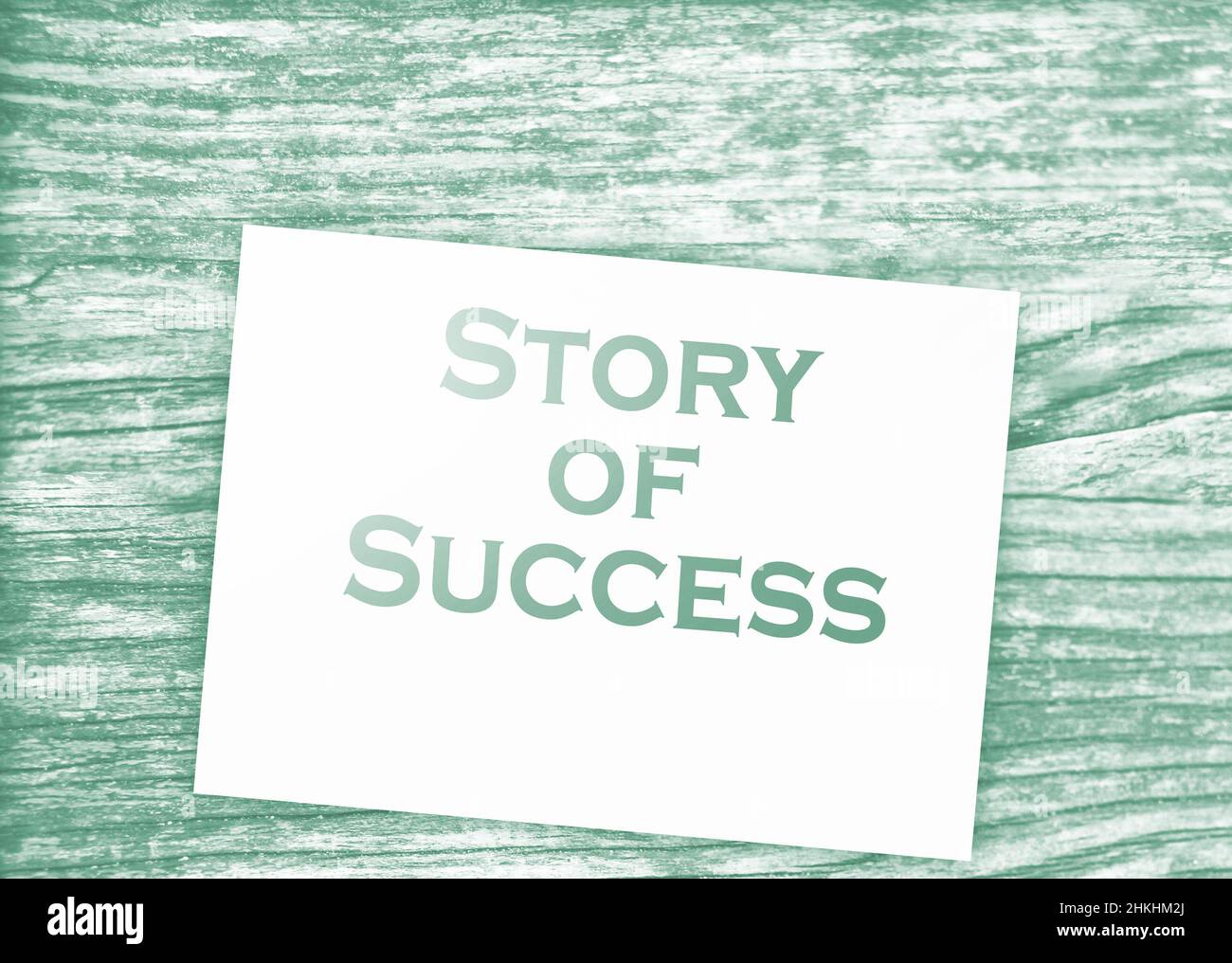 Success story typed on page and paper dollar signs around on wooden ...