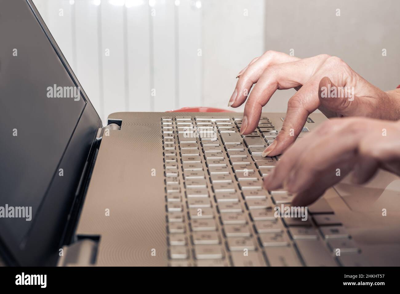 Female hands on laptop keyboard at home. Homeschooling and remote work ...