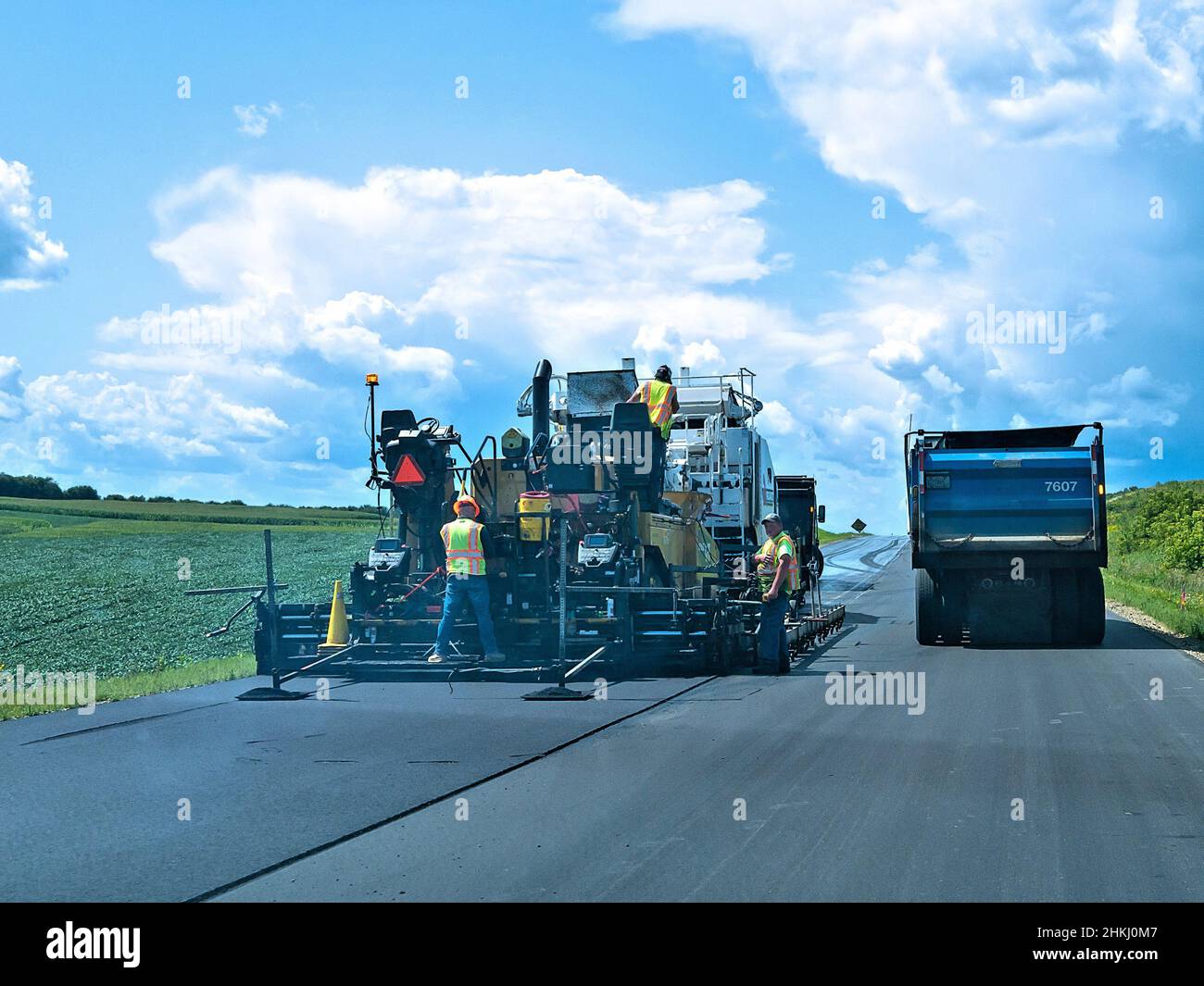 Highway road construction work zone with trucks and machines and men ...