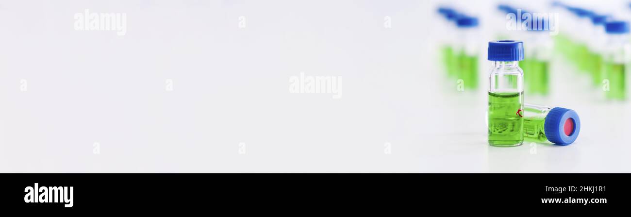 Banner with HPLC vials with green sample on the white background with ...