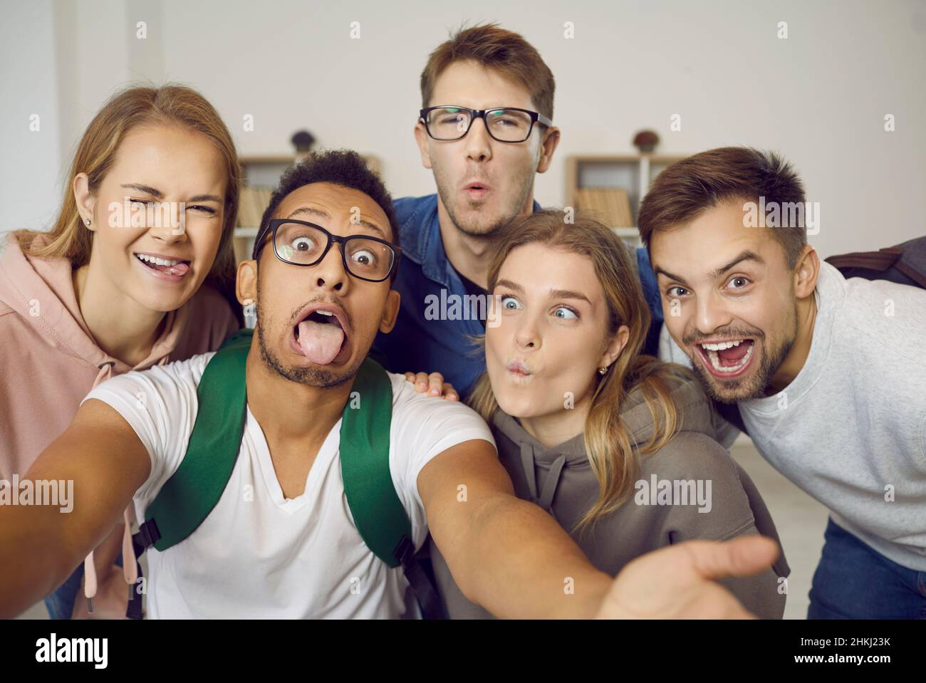 Multiracial group of happy students taking a funny selfie and making ...