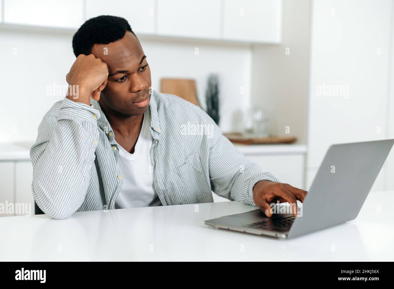 Bored frustrated african american guy, freelancer, designer, sitting at ...