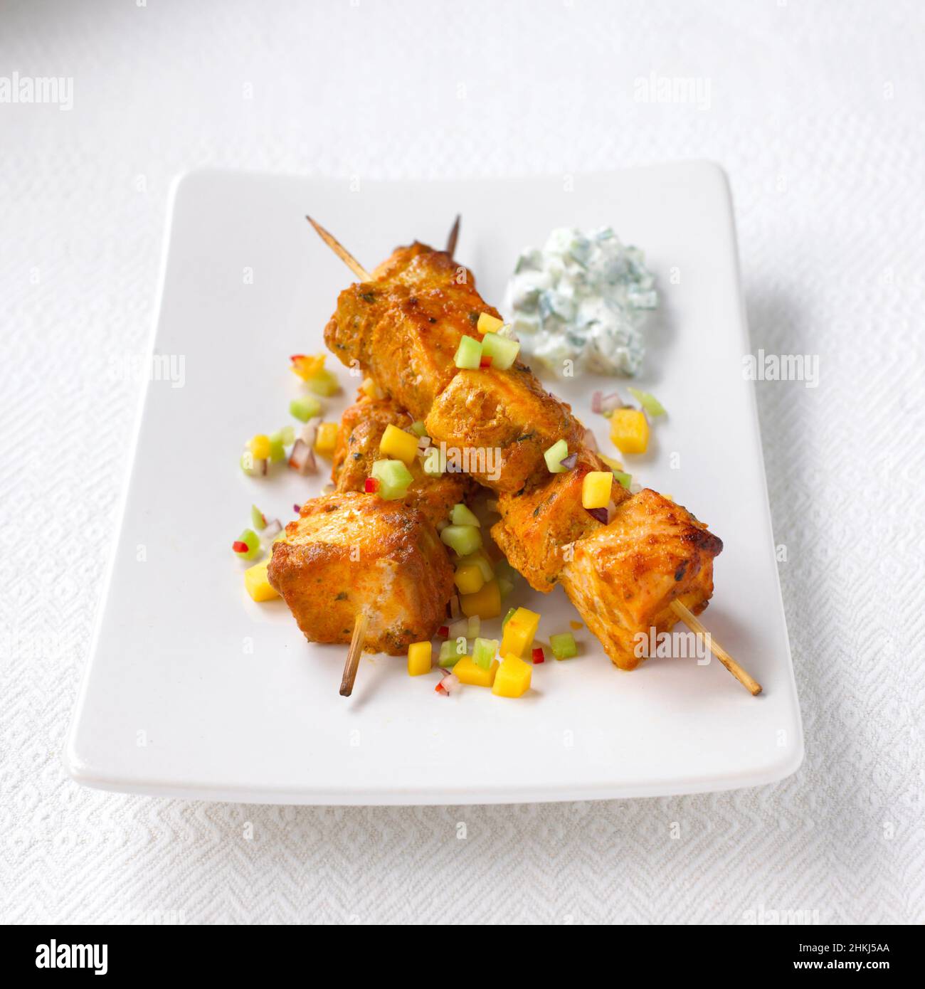 Mixed tikka fish kebabs with mango salsa and lime raita Stock Photo - Alamy