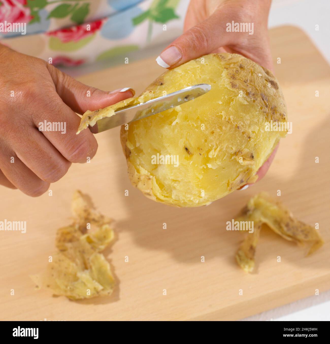 Peeling the skin off a cooked jacket potato Stock Photo - Alamy