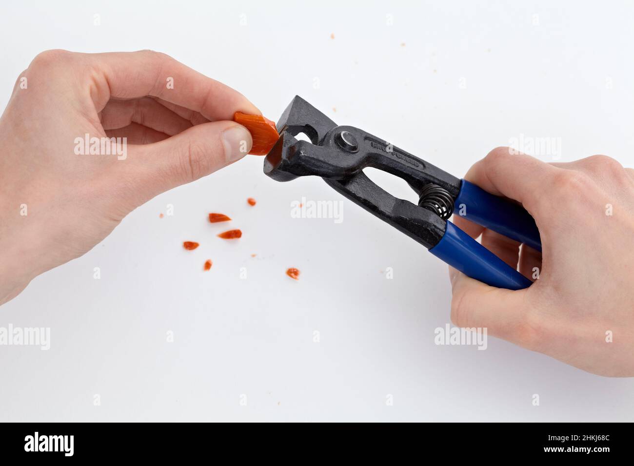 Using nippers to shape edge on piece of ceramic tile Stock Photo - Alamy