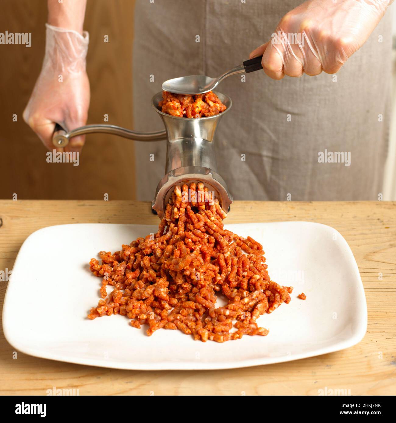 Man using table top hand operated mincer Stock Photo - Alamy