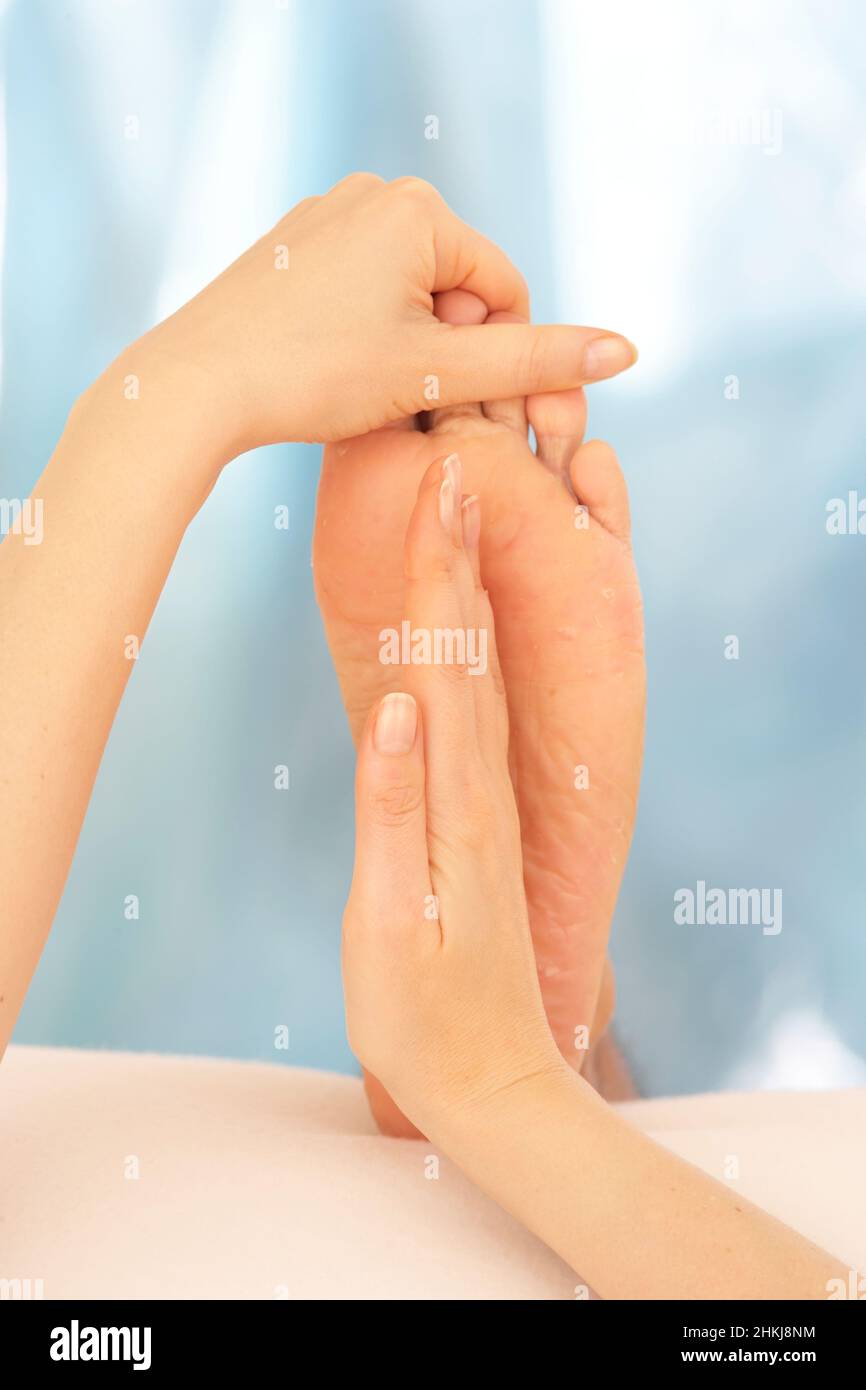 Reflexologist applying tapping technique to foot Stock Photo - Alamy