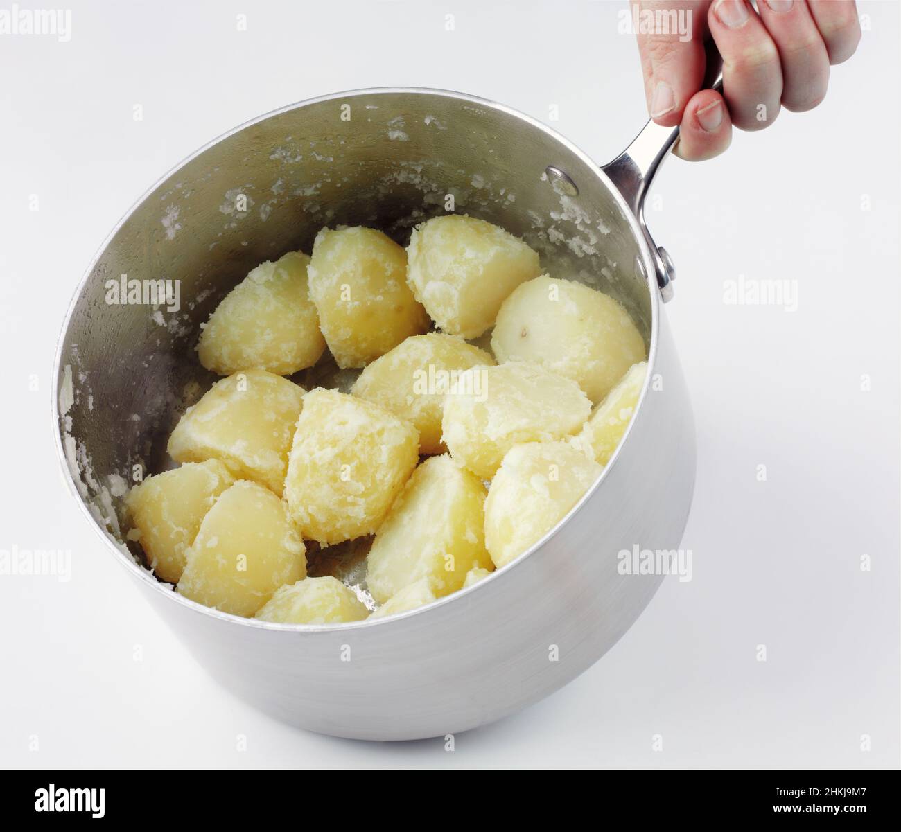 Returning pre-cooked and drained potatoes to the pan Stock Photo - Alamy
