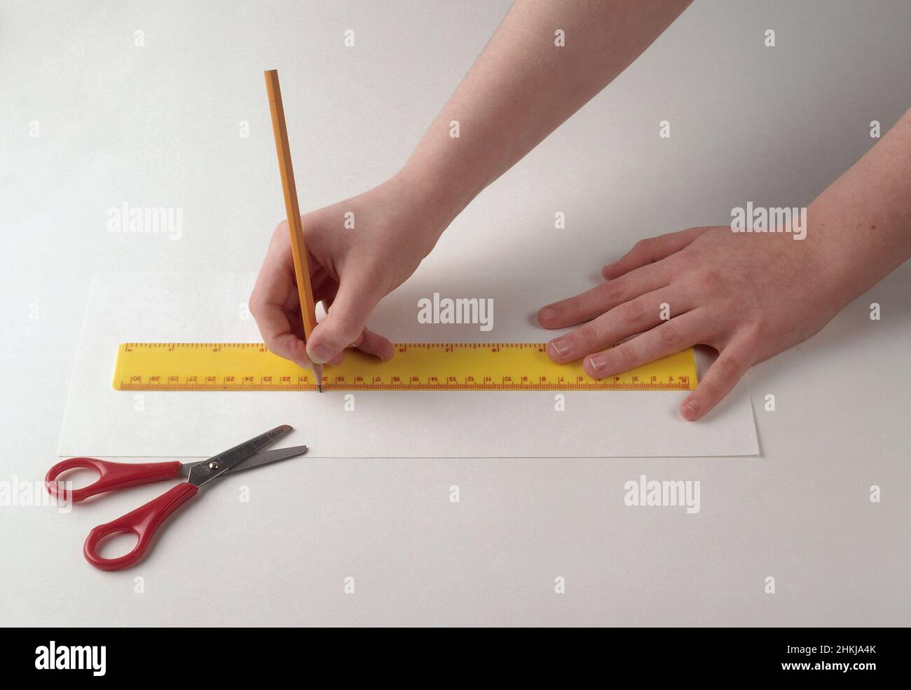 Hands drawing line holding yellow ruler and pencil Stock Photo - Alamy