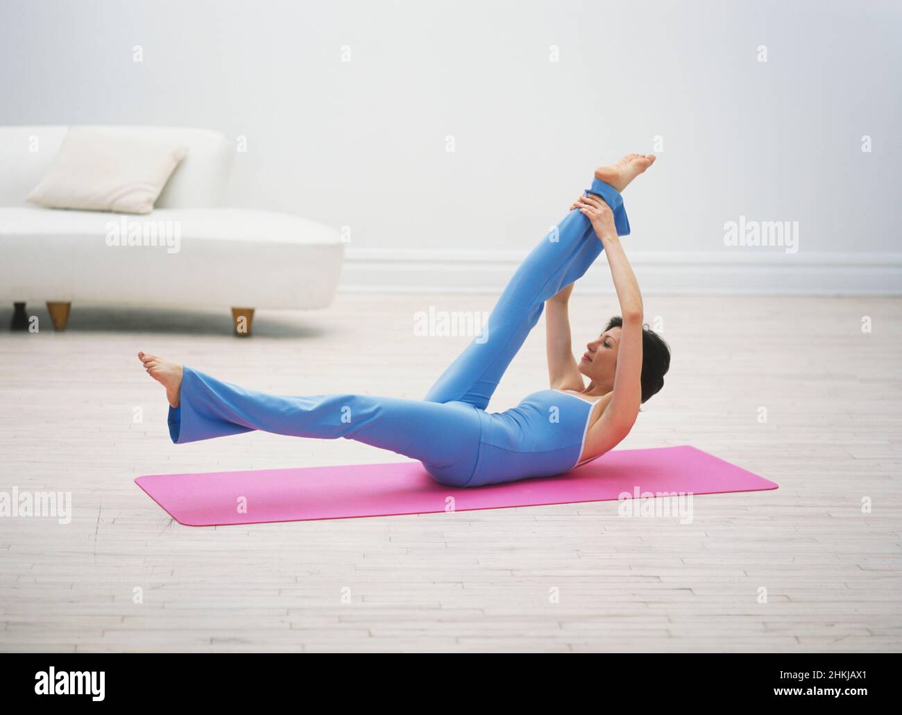 Woman stretching leg over her head Stock Photo - Alamy