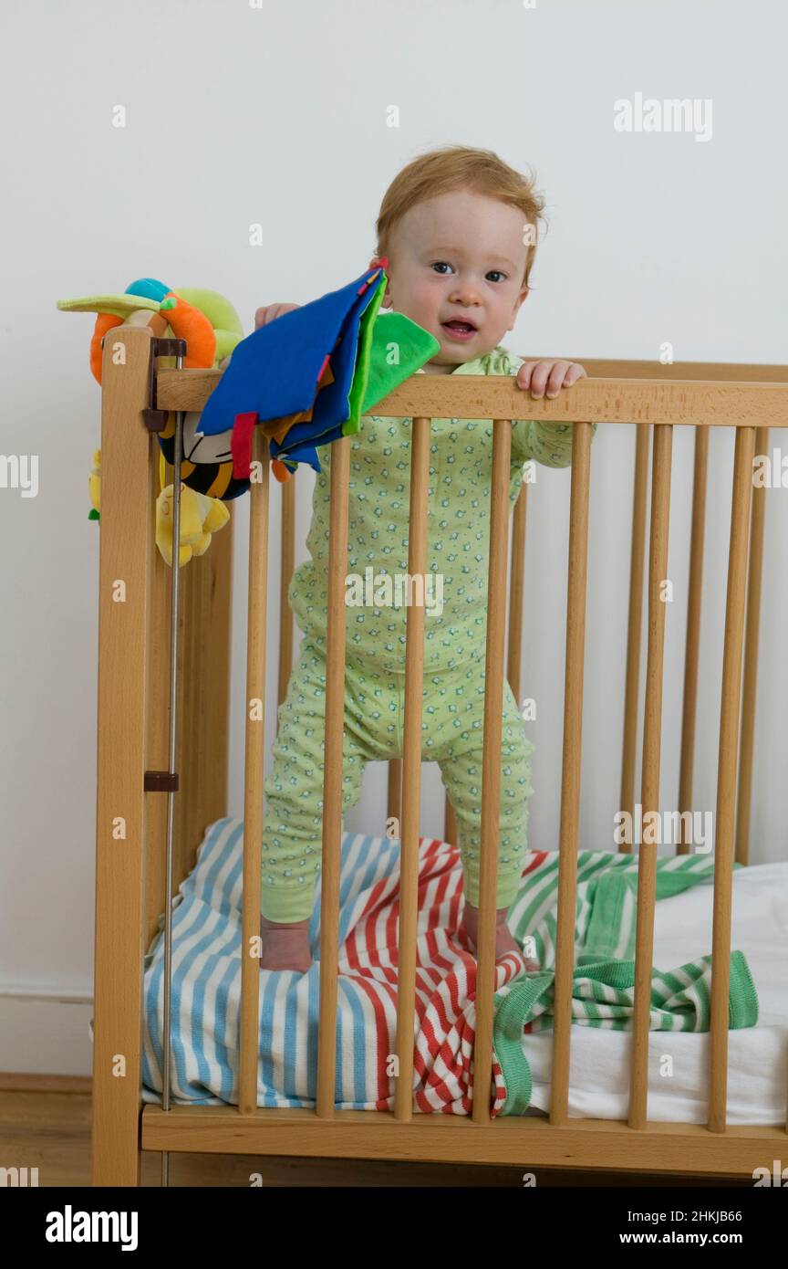 Baby boy standing in cot Stock Photo - Alamy