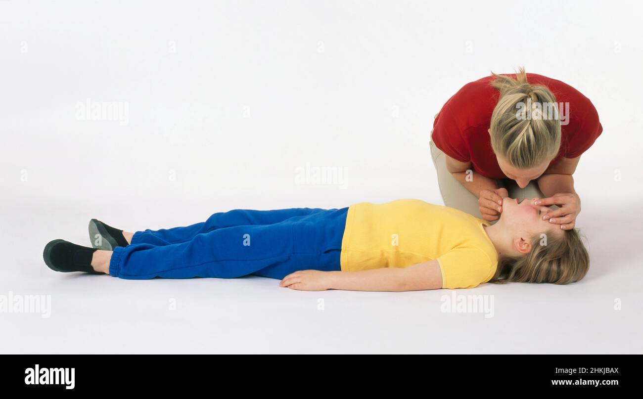 Girl lying on back being resuscitated by woman Stock Photo - Alamy