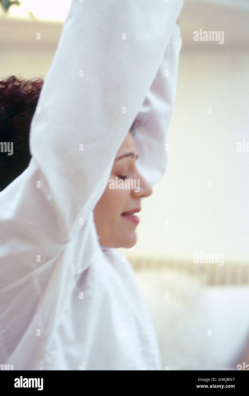 Woman with arms straight up over her head and eyes closed Stock Photo ...