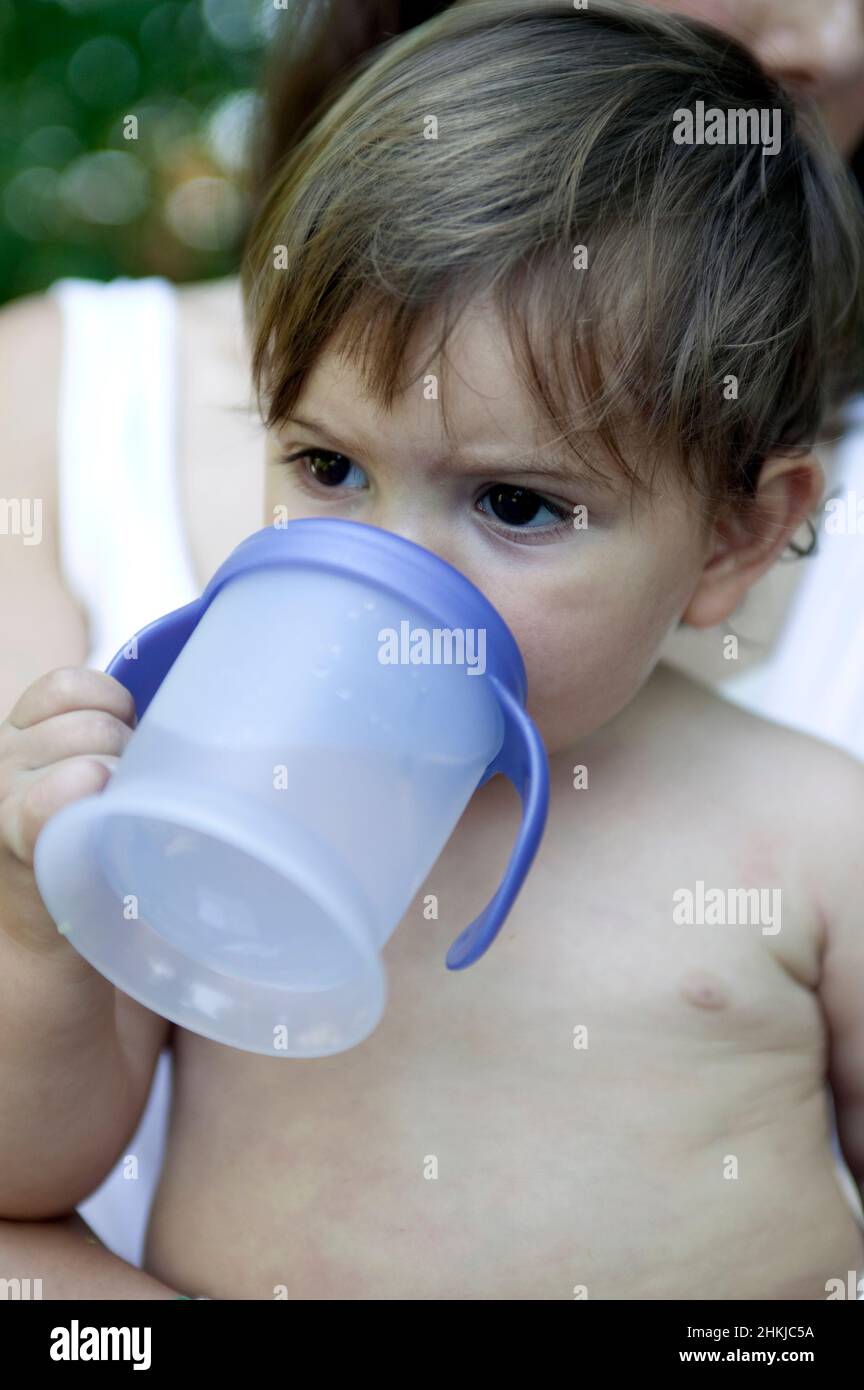 Baby boy drinking from plastic beaker Stock Photo - Alamy