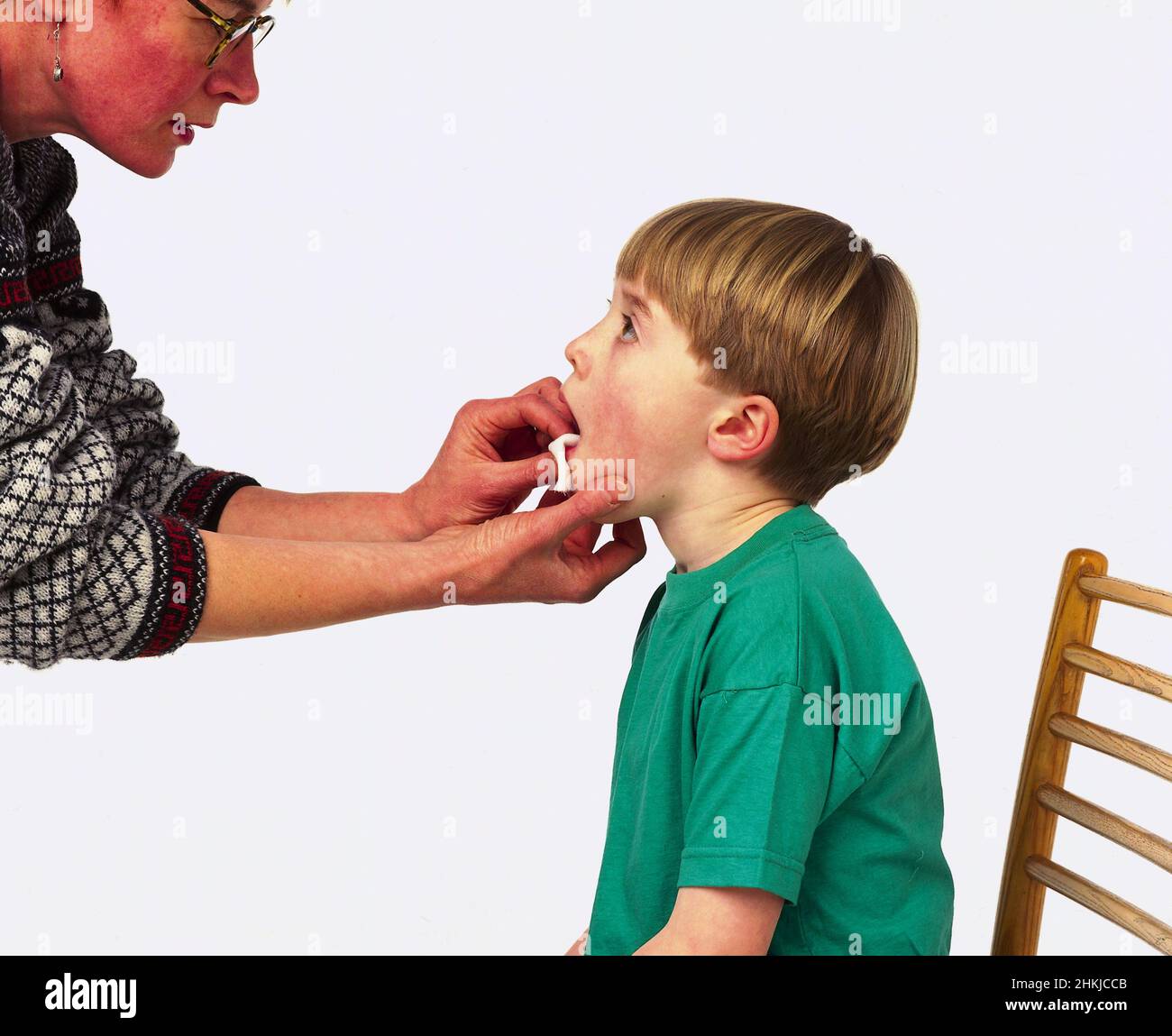 Pressing on boy's mouth wound with pad Stock Photo - Alamy