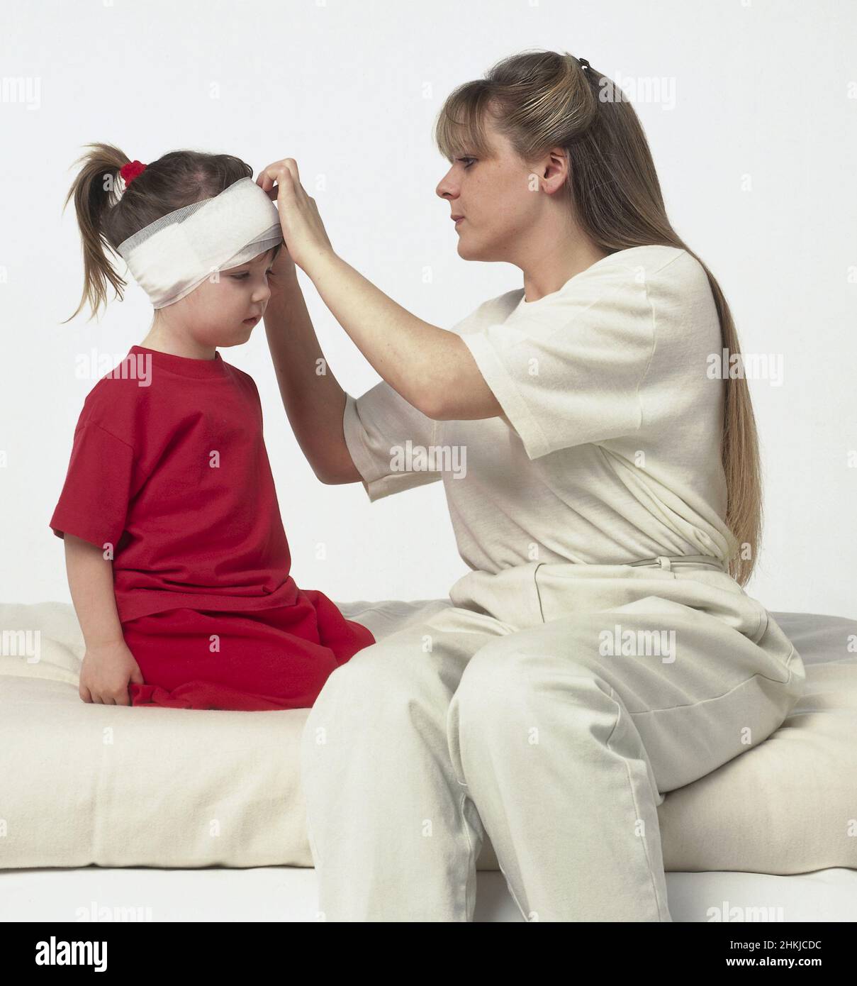 Bandaging girl's ear Stock Photo - Alamy