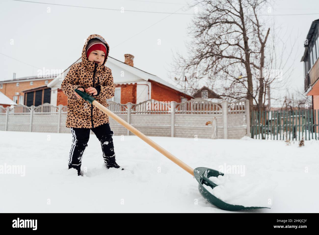 Low angle view of the little kid girl helping to clean pathway from ...