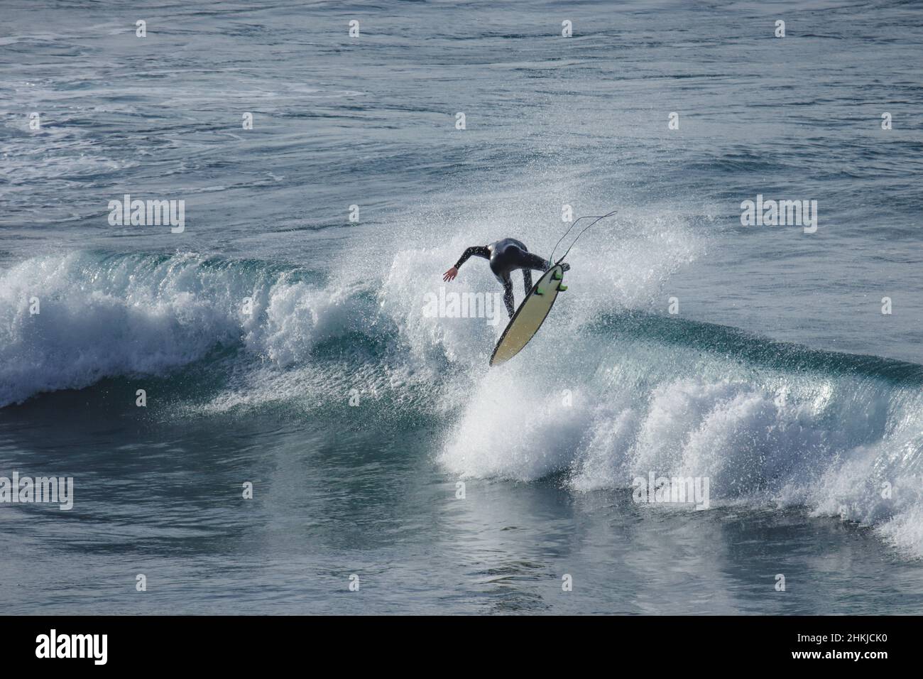 Surfer makes an aerial maneuver in a perfect wave Stock Photo - Alamy
