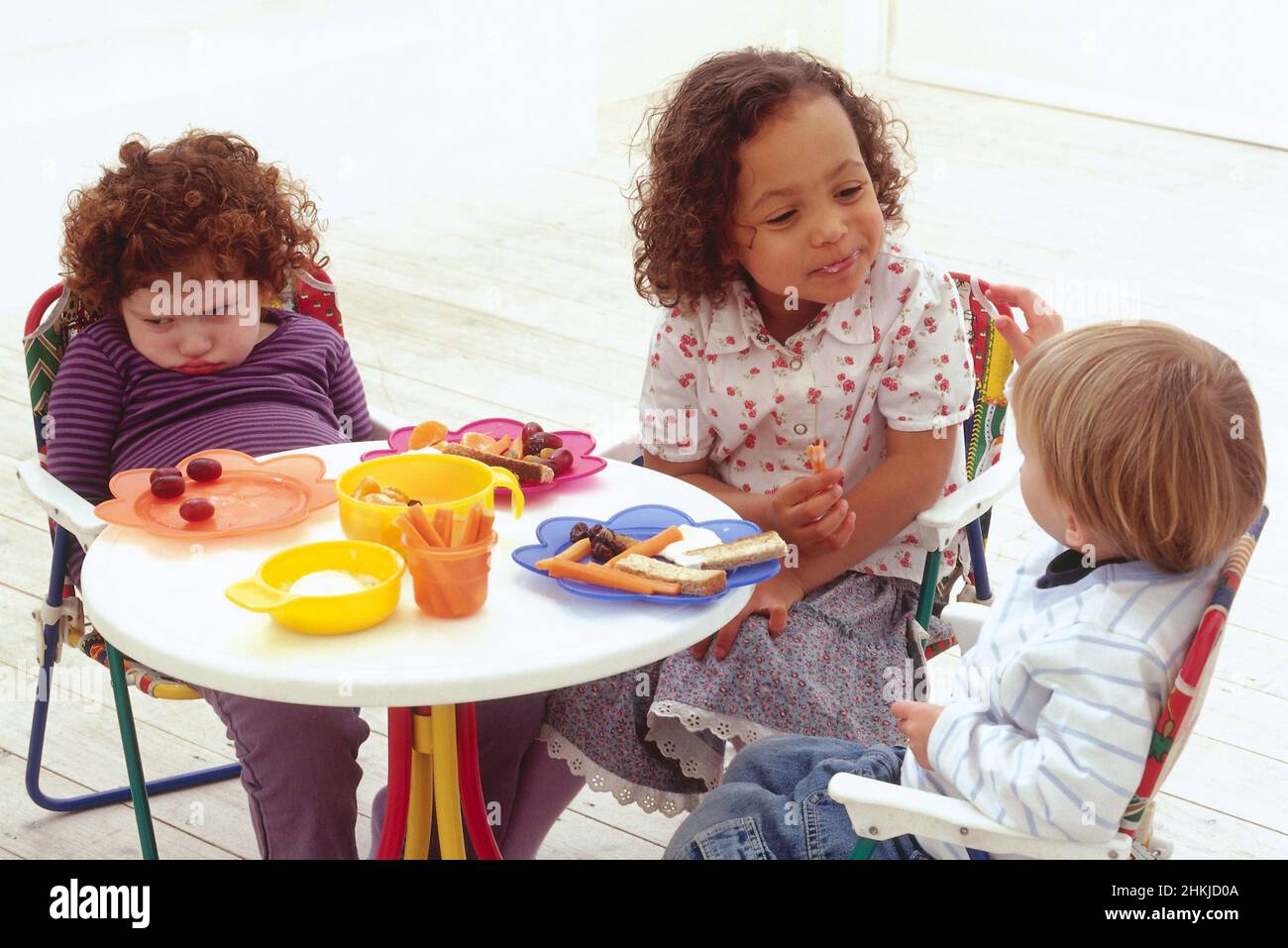 Group of young girls sitting around a table Stock Photo - Alamy
