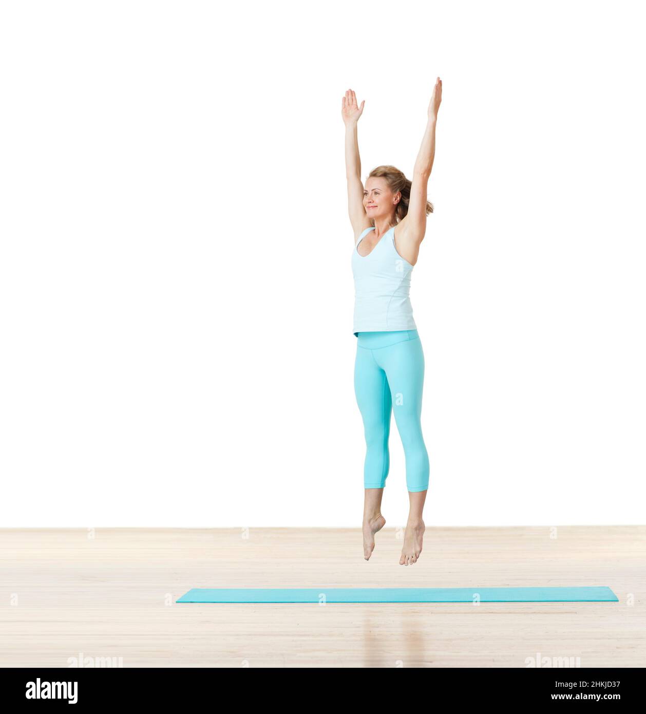 Woman practising standing jump Pilates mat exercise Stock Photo - Alamy