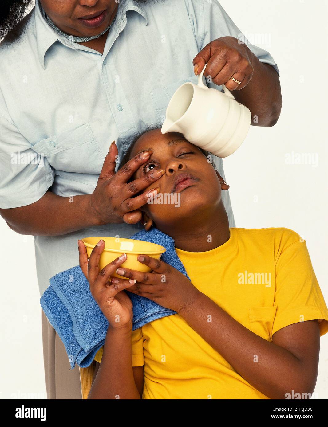 Rinsing foreign body from child's eye using jug of water Stock Photo ...