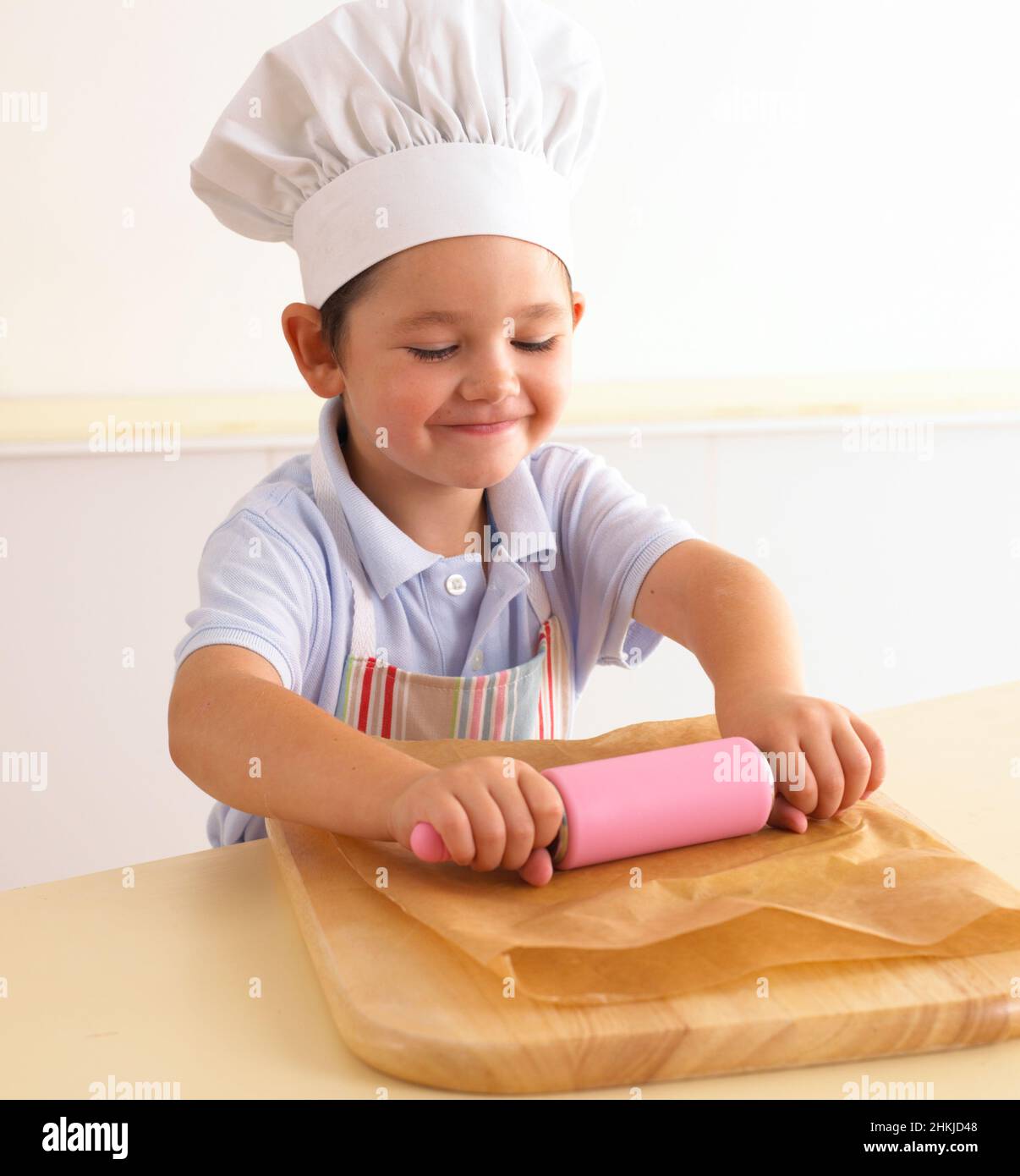 Boy using rolling pin to flatten cookie dough Stock Photo - Alamy
