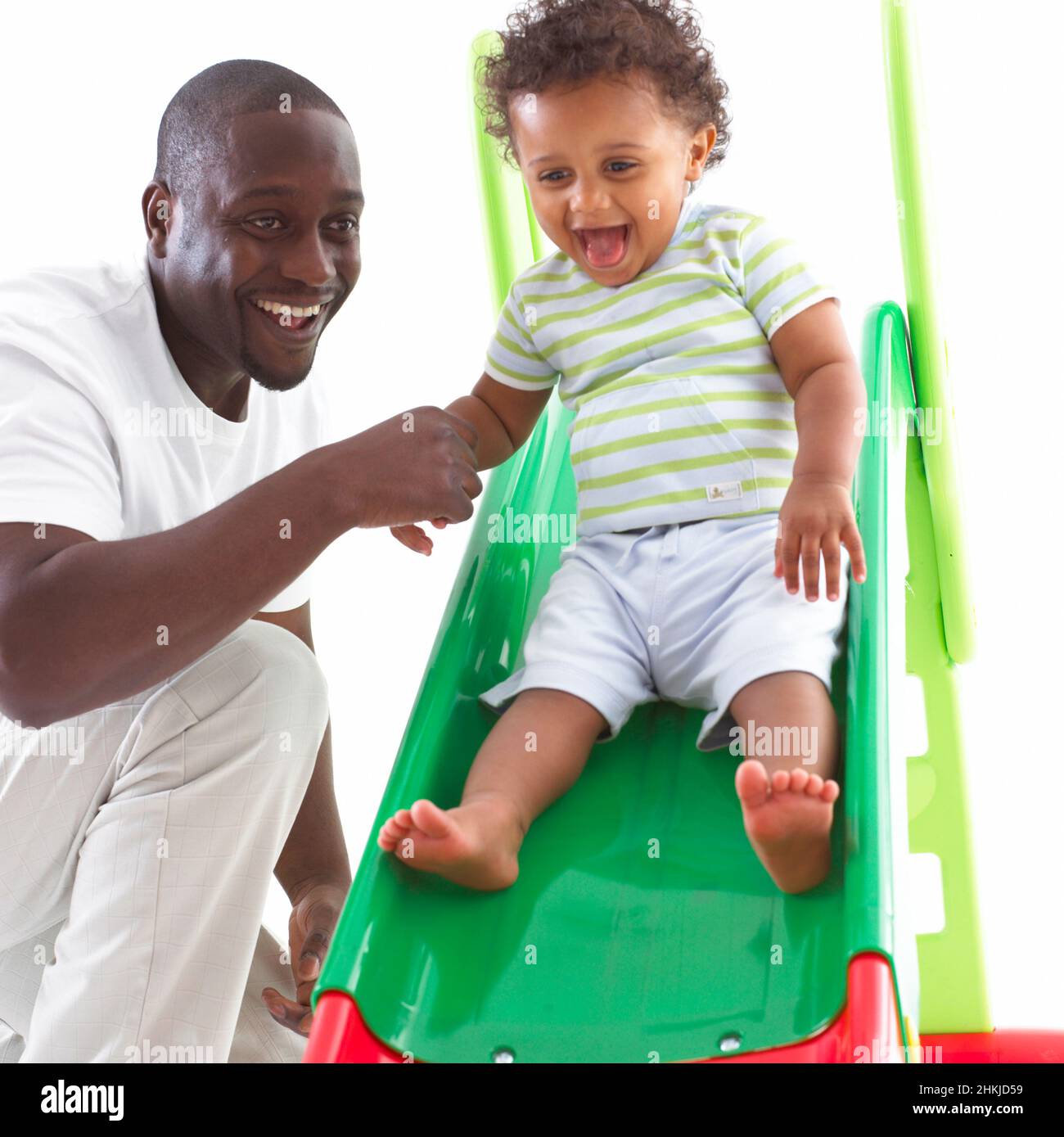 Toddler boy sliding down slide Stock Photo - Alamy