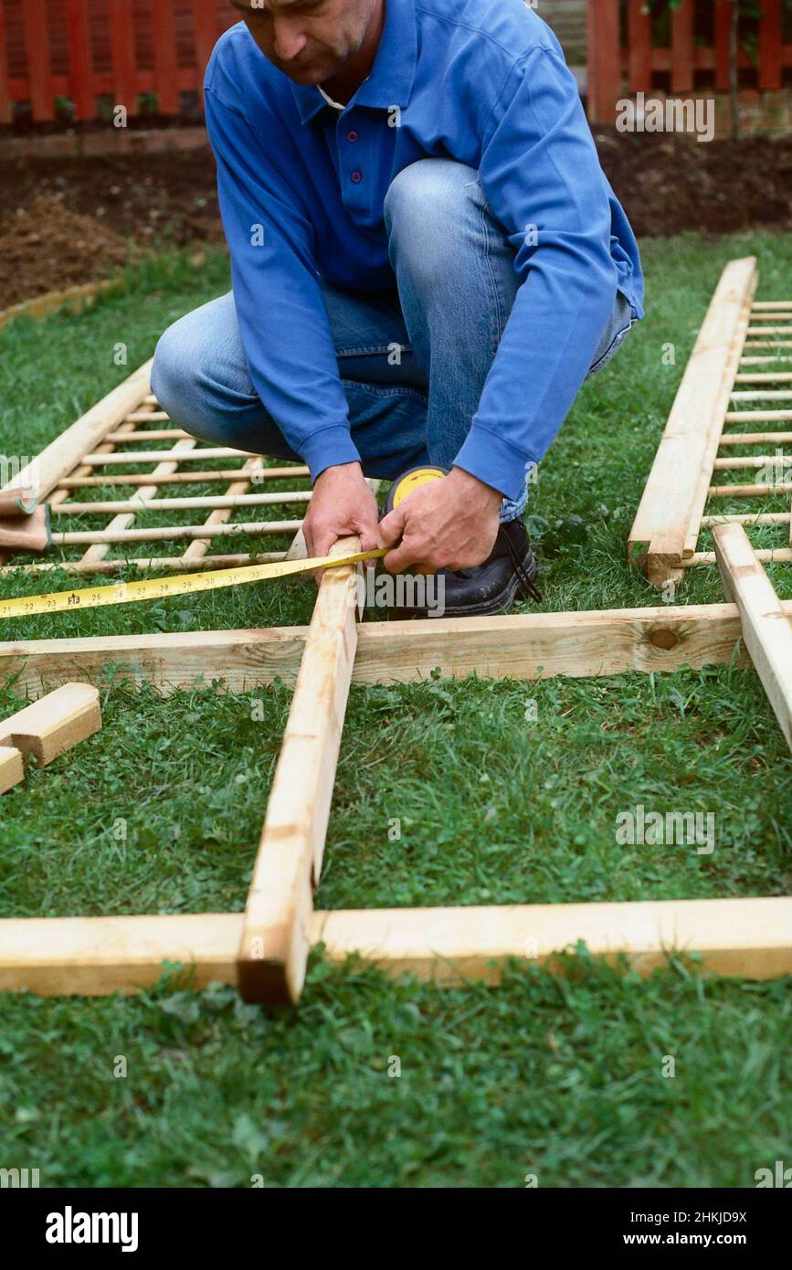 Man measuring wood with tape measure Stock Photo - Alamy