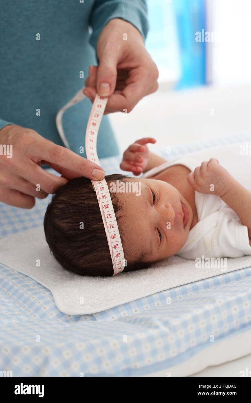 Four week old baby having it's head measured Stock Photo - Alamy