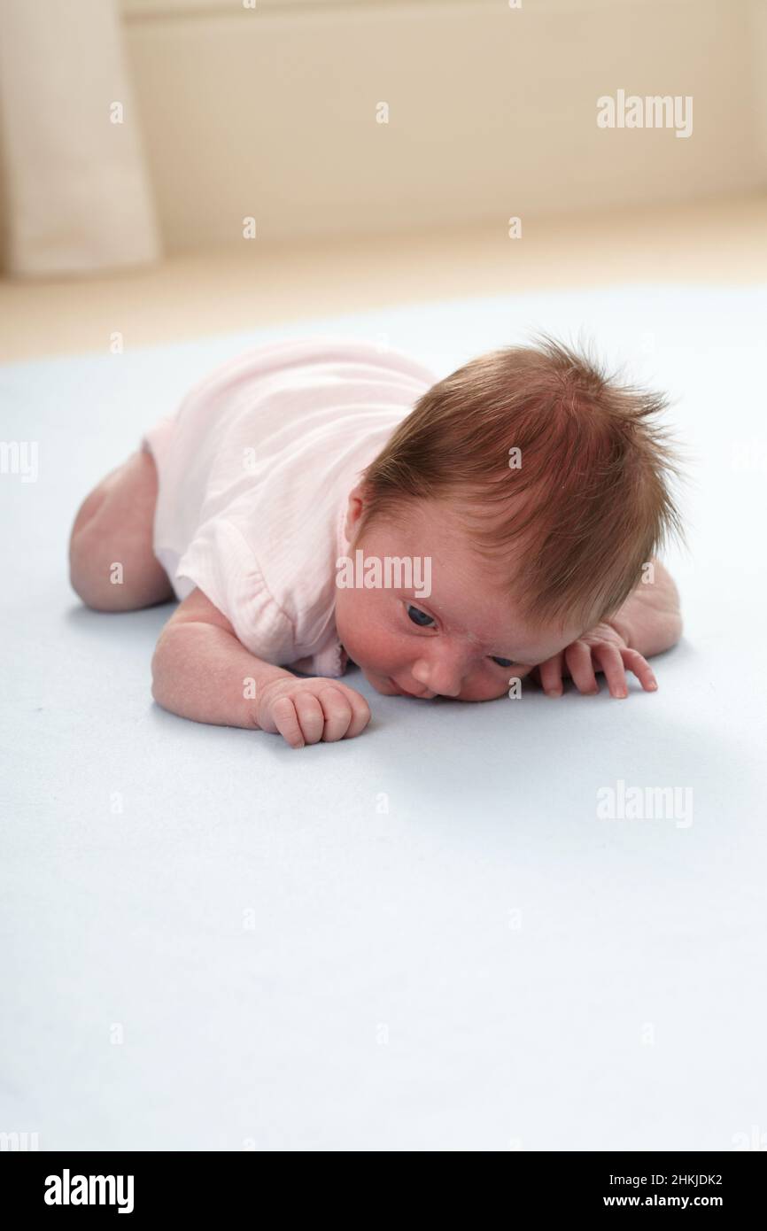 Baby girl lying on her front Stock Photo - Alamy