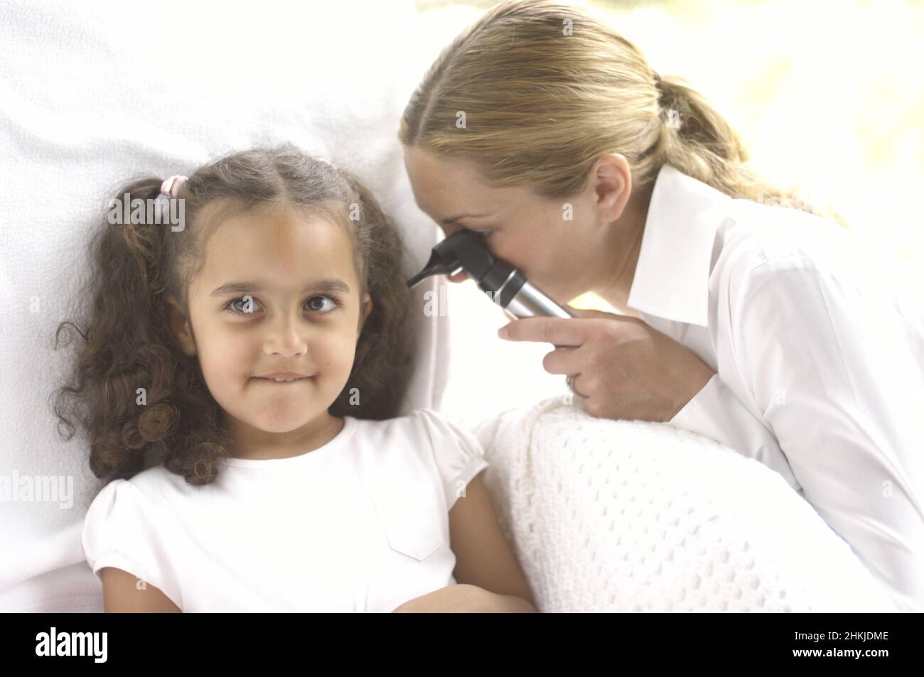 Female doctor examining girls ear Stock Photo - Alamy