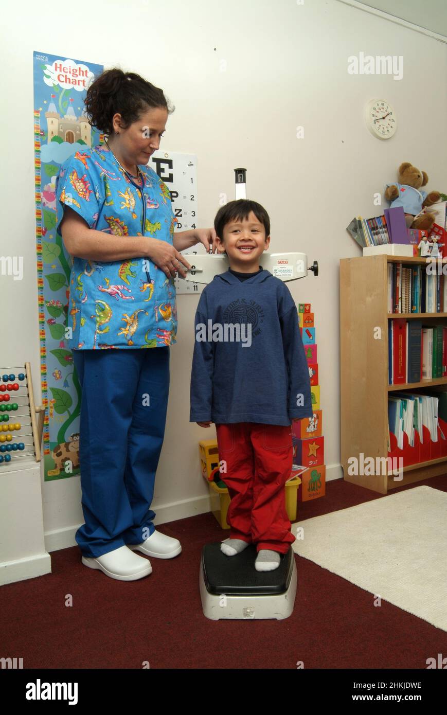 Boy standing on scales next to nurse Stock Photo - Alamy