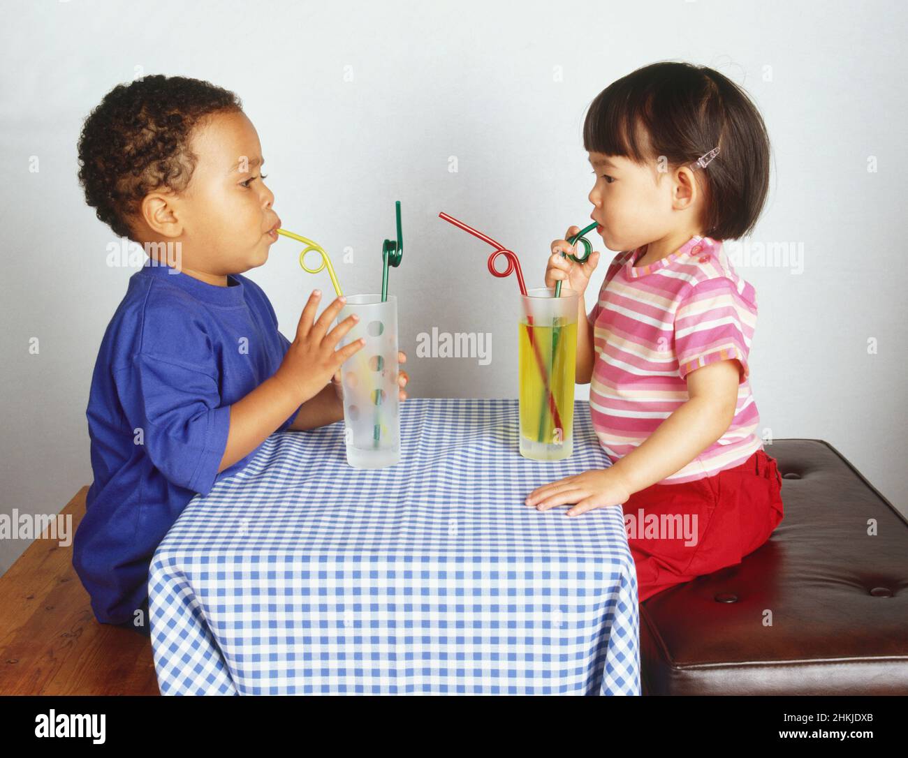 Boy and girl drinking through straws Stock Photo - Alamy