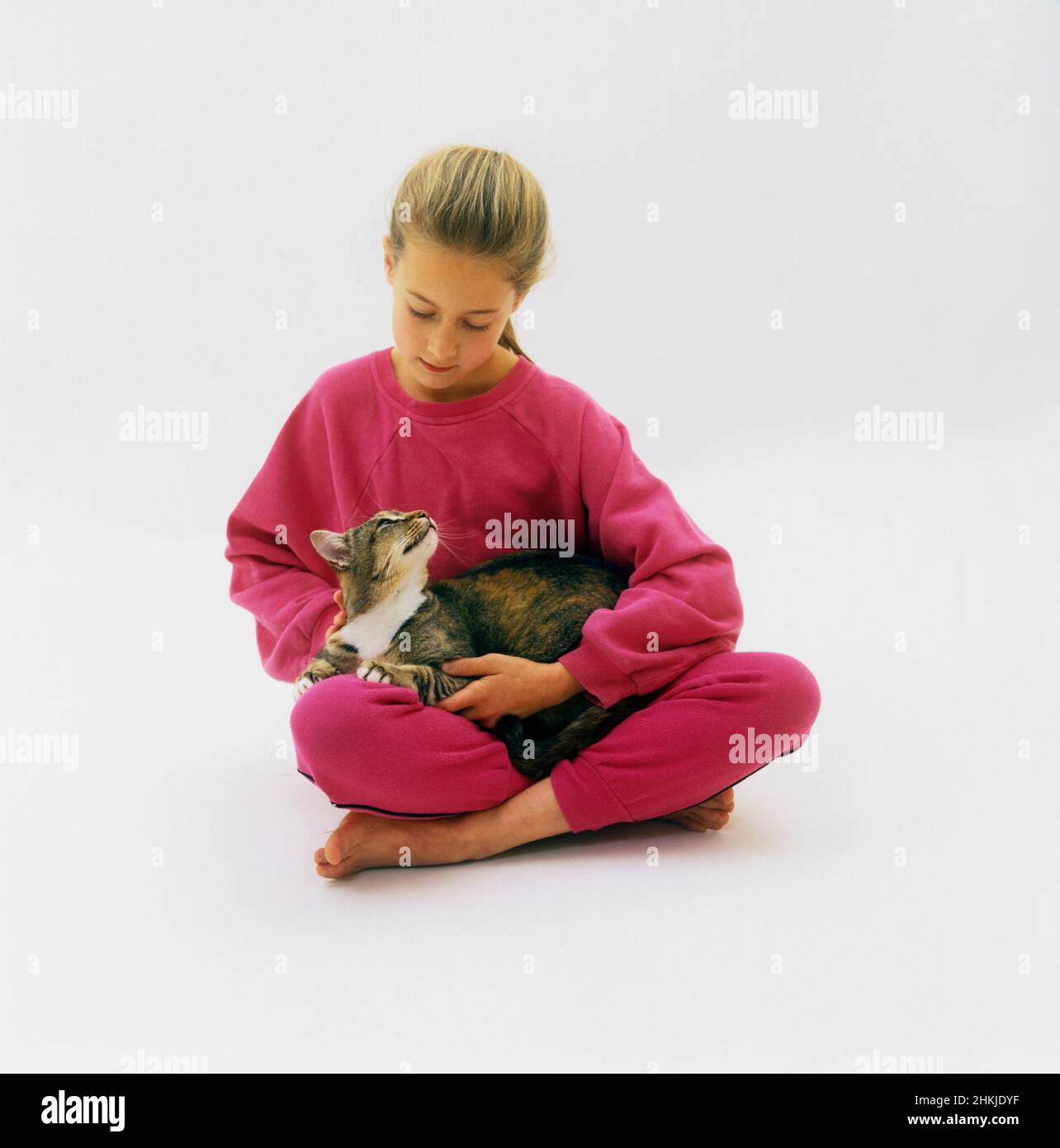 Girl sitting cross-legged with cat on lap Stock Photo - Alamy