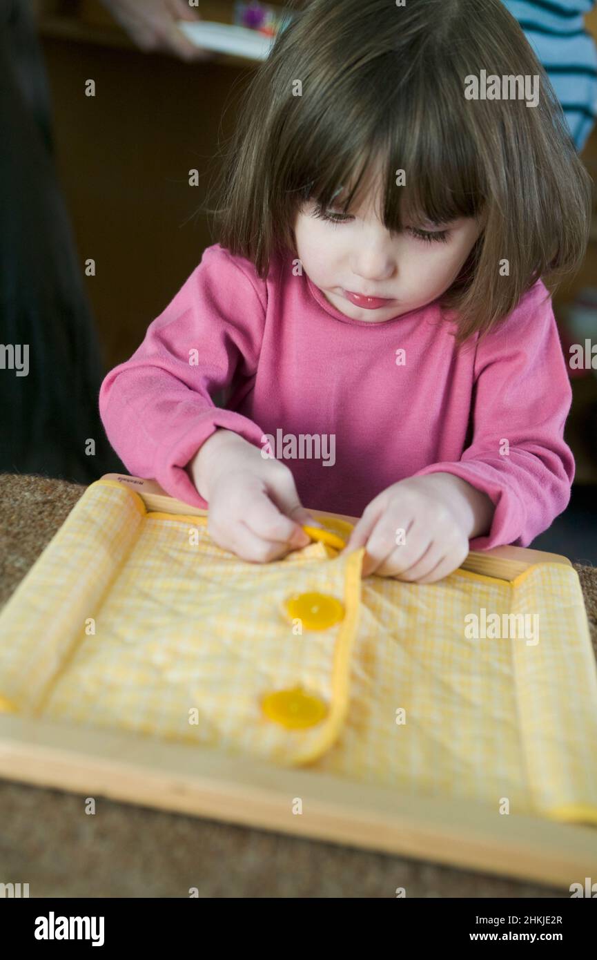 Girl buttoning up fabric in frame Stock Photo - Alamy