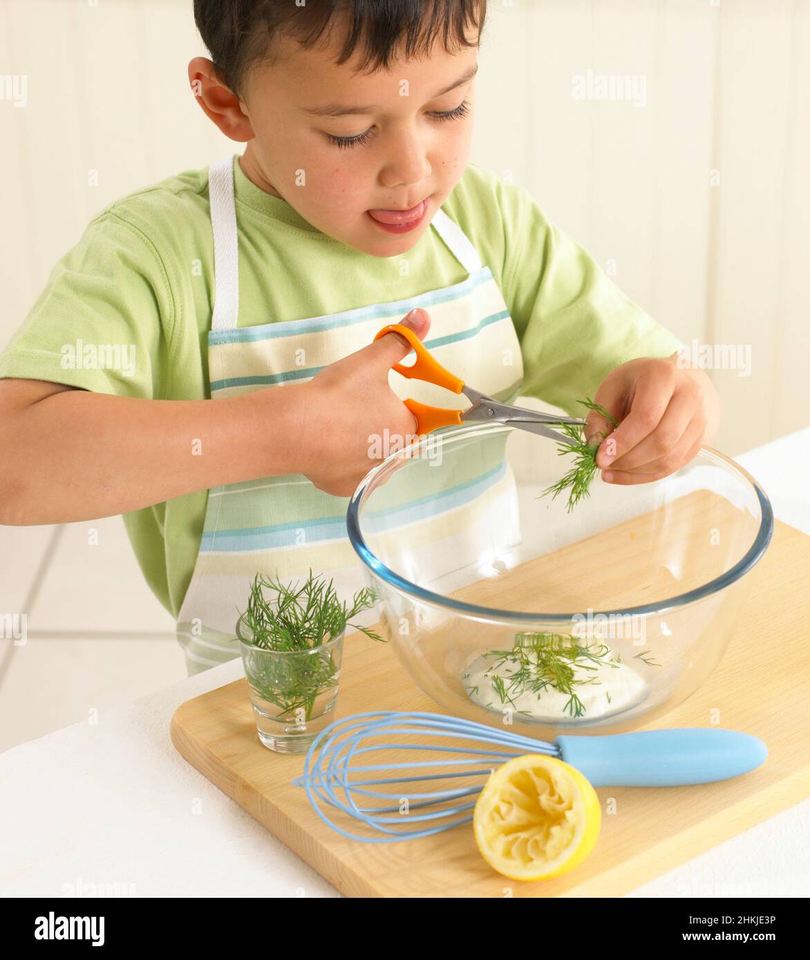 Boy cutting dill into a bowl Stock Photo - Alamy