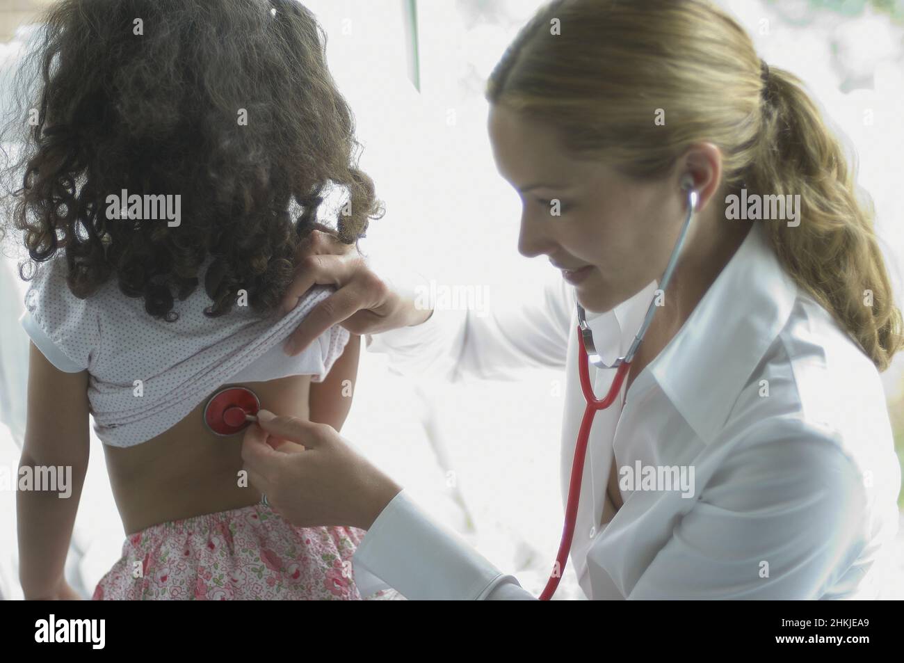 Doctor holding stethoscope on girl's back Stock Photo - Alamy