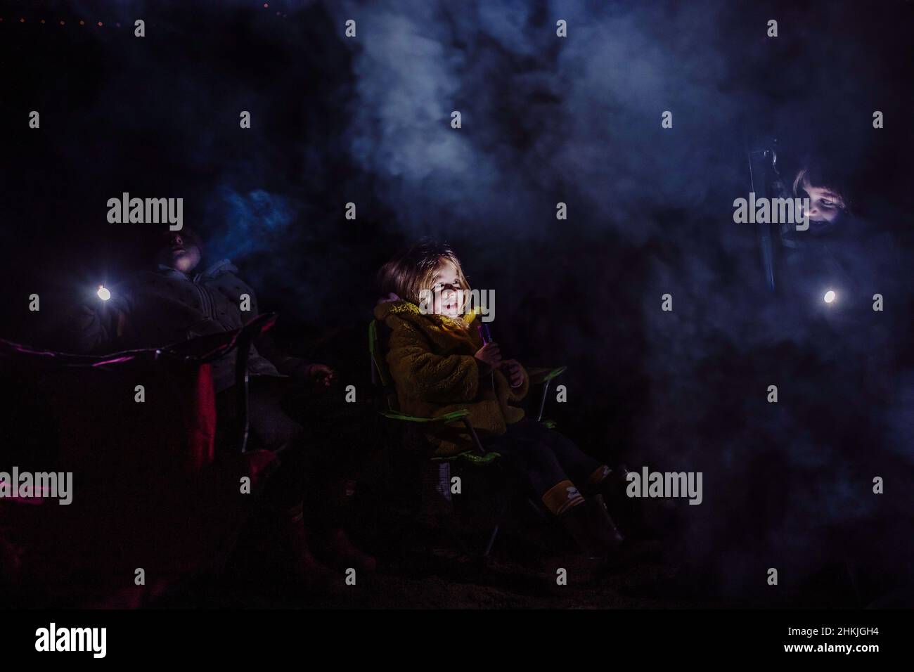Kids telling ghost stories around campfire Stock Photo - Alamy