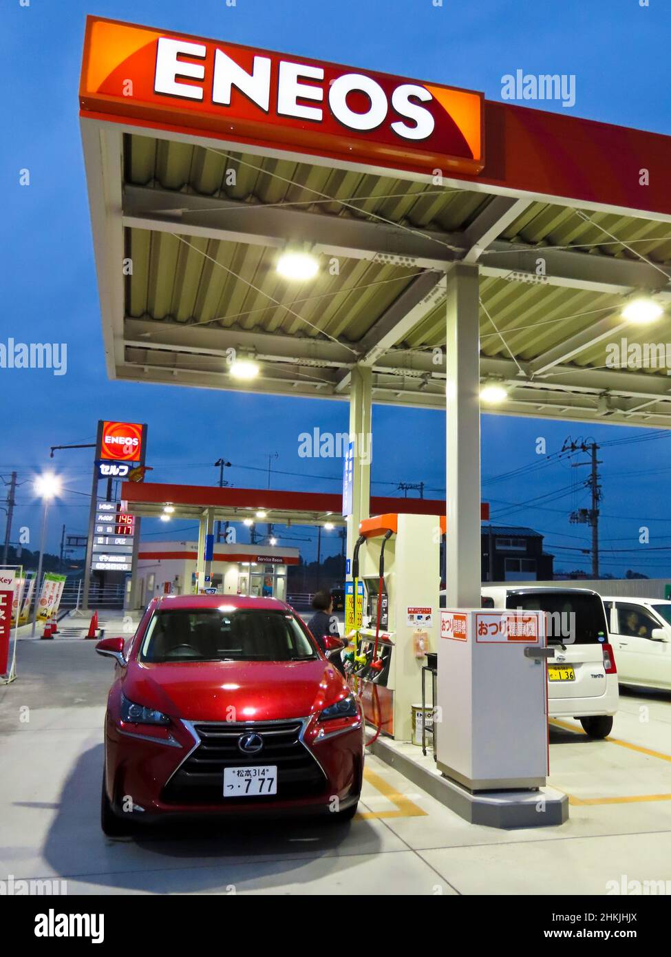 Woman using petrol pump, Japan Stock Photo - Alamy