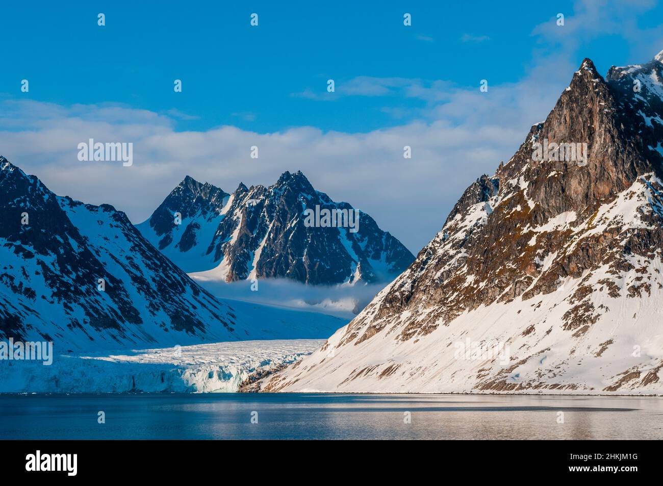 Ice covered mountains and a glacier border Stock Photo - Alamy